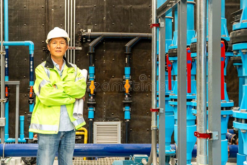 Asian Man Worker in Protective Uniform and with Hardhat Using Tablet ...