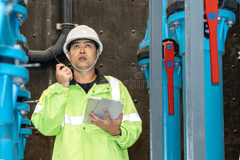 Asian Man Worker in Protective Uniform and with Hardhat Using Tablet ...