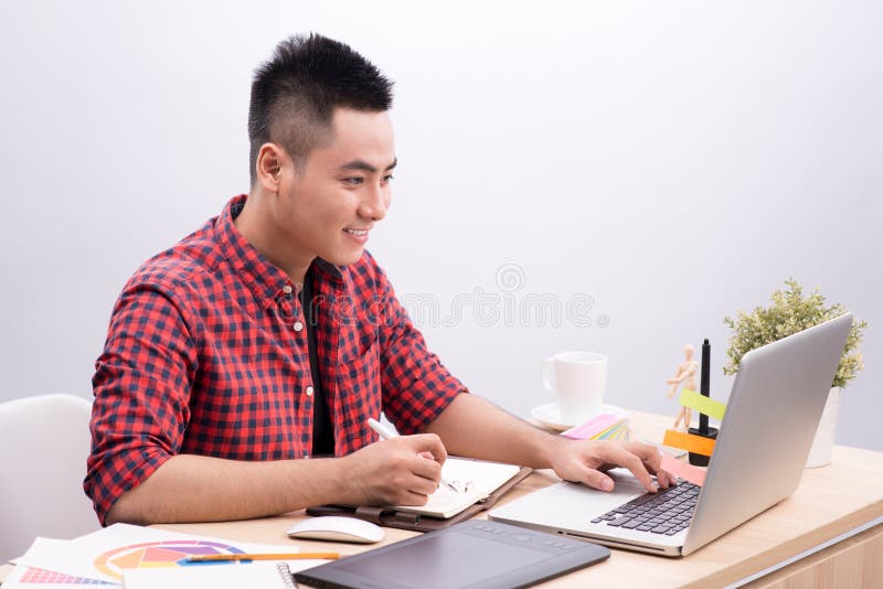 Asian Man Writing at Desk in Busy Creative Office Stock Image - Image ...