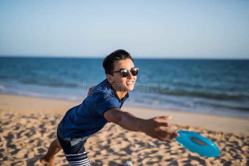Asian Manplaying Frisbee on the Sea Beach. Sumner Vocation Stock Photo ...