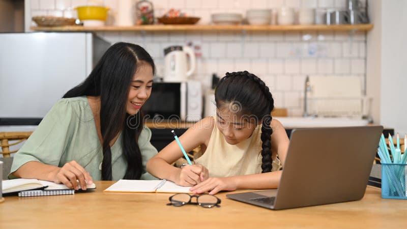 Asian Mom Helping Her Sweet Daughter Doing Homework, Learning Online at ...