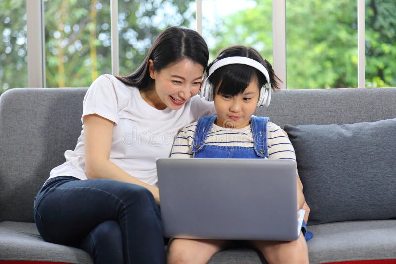 Asian Mother Teaching Her Daughter To Learn From Online Class Using