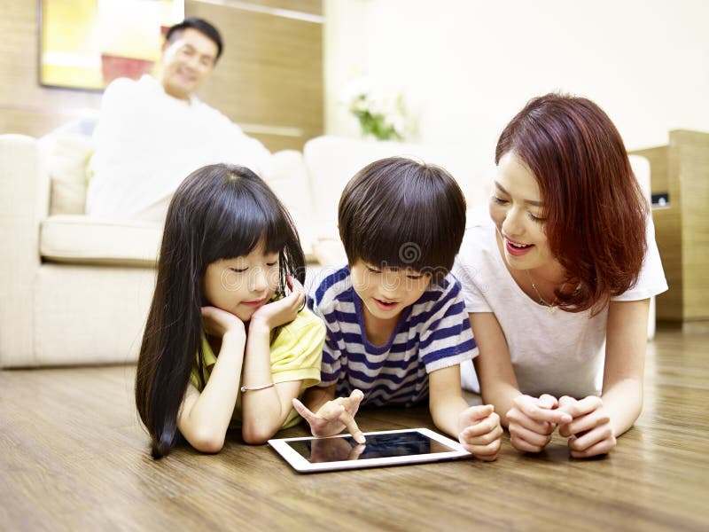 Asian Mother And Two Children Using Digital Tablet Together Stock Image ...