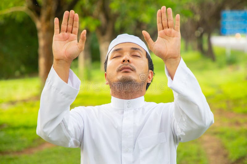 Asian Muslim Man Standing and Praying while Raised Arms on the Dune ...