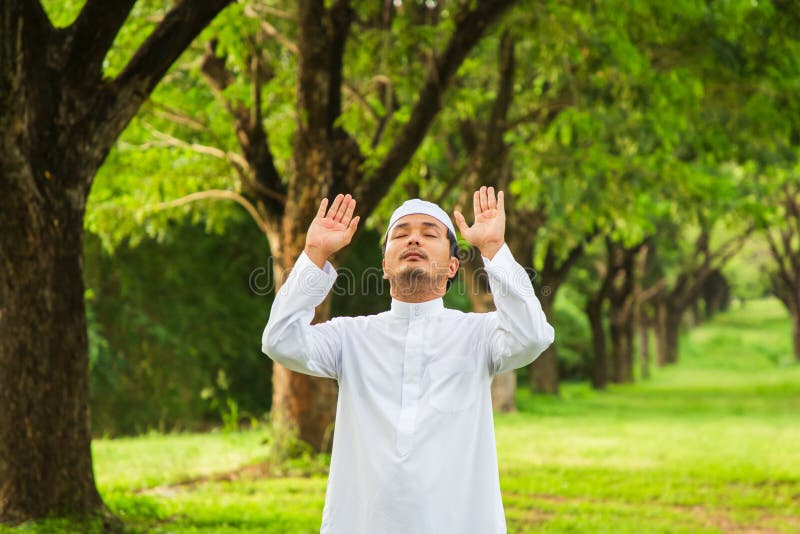 Asian Muslim Man Standing and Praying while Raised Arms on the Dune ...