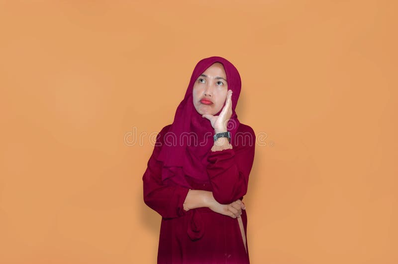 Asian Muslim Woman Wearing Hijab Thinking And Looking Up On Orange