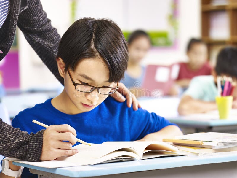 Asian Primary School Student Getting Help from Teacher Stock Image ...
