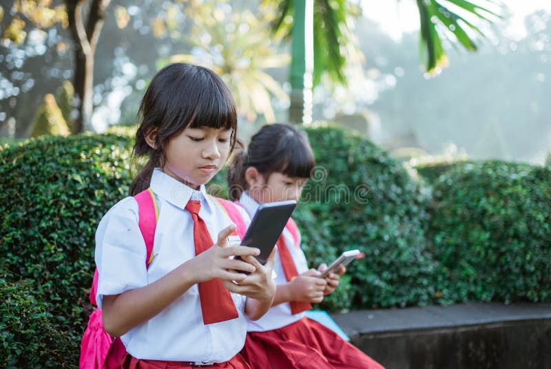 Asian Primary Student Using Mobile Phone in School Park Stock Image ...