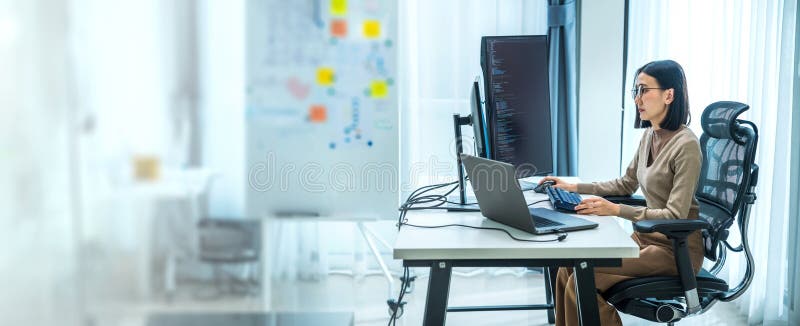 Asian Prompt Engineer Develop Coding App With Software Data Sitting In Front Of Computer Monitor