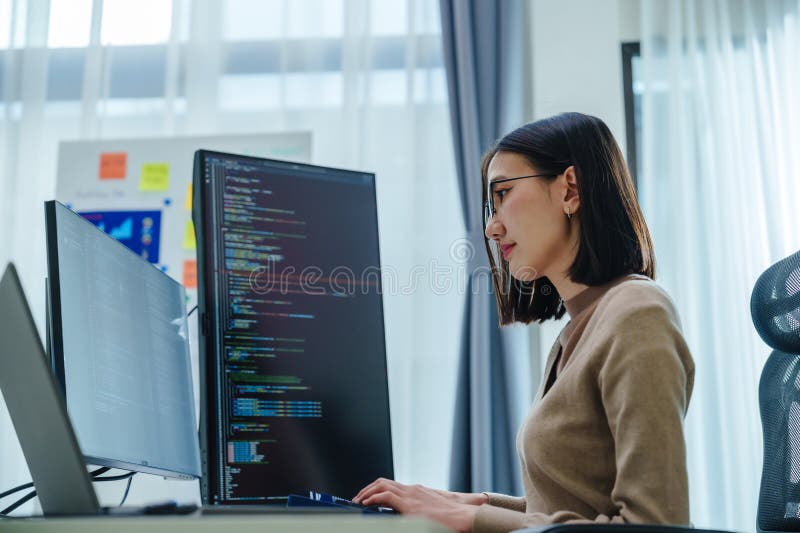Asian Prompt Engineer Develop Coding App With Software Data Sitting In Front Of Computer Monitor