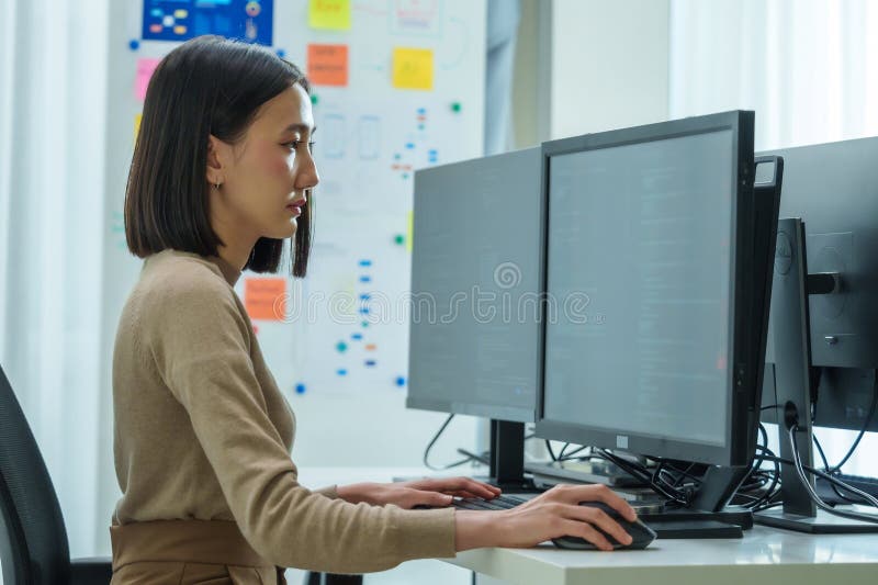 Asian Prompt Engineer Develop Coding App With Software Data Sitting In Front Of Computer Monitor