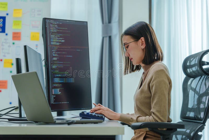 Asian Prompt Engineer Develop Coding App With Software Data Sitting In Front Of Computer Monitor