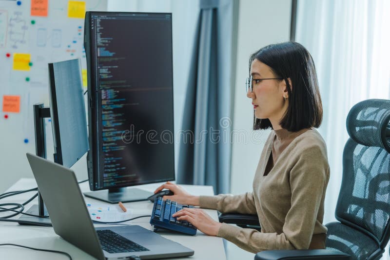 Asian Prompt Engineer Develop Coding App With Software Data Sitting In Front Of Computer Monitor