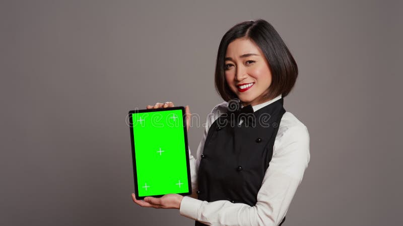 Asian Restaurant Hostess Showing Greenscreen Display in Studio Stock ...