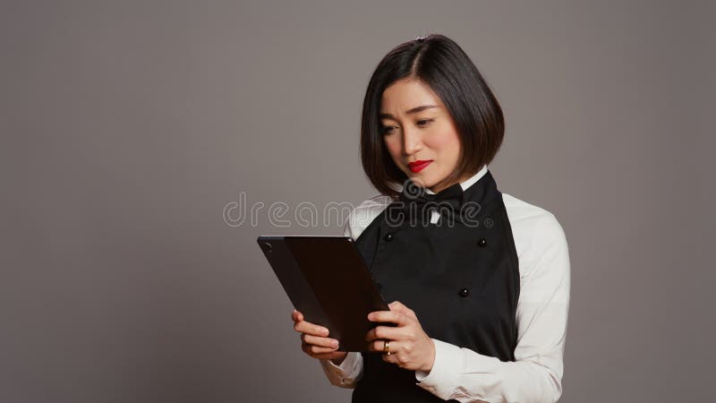 Asian Restaurant Server Checking All Table Reservations on Tablet Stock ...
