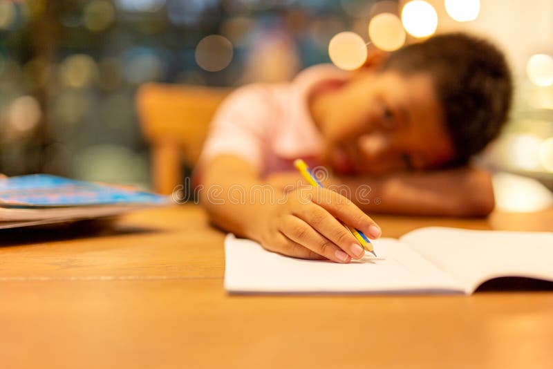 Asian School Boy Holding Pencil with Head on Table while Doing Homework ...