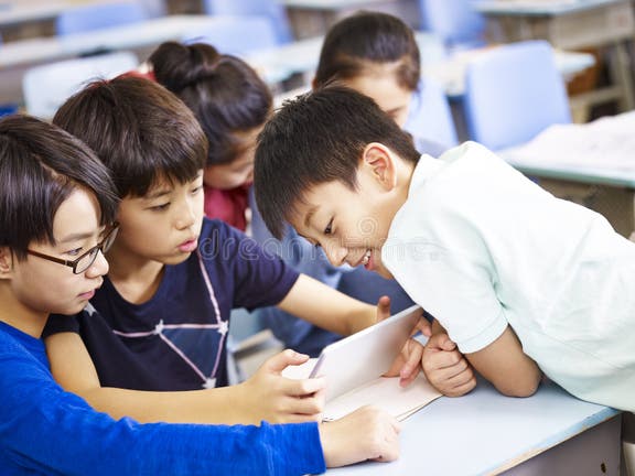 Asian Schoolchildren Using Digital Tablet Together Stock Image - Image ...