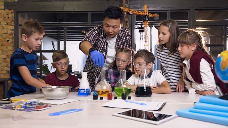 Asian Science Teacher with Kids in Lab Class Working about Experiment ...