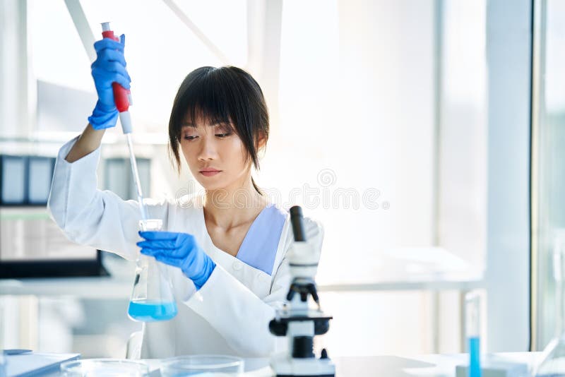 Asian Scientist Working in Big Modern Laboratory Doing Some Research ... Asian Scientist Working in Big Modern Laboratory Doing Some Research ...
