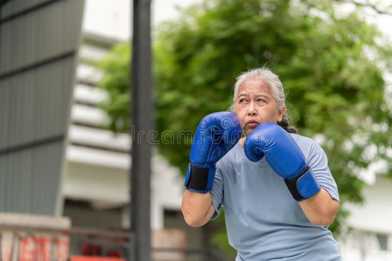 Asian Senior Sportswoman Boxing while Working Out Outdoors Stock Image ...