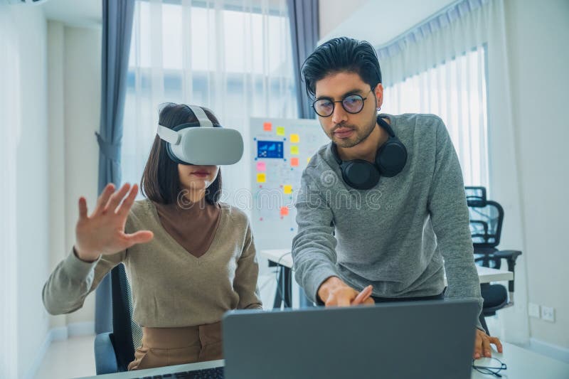 Asian Software Developer Wearing a Virtual Reality Headset Works on a ...