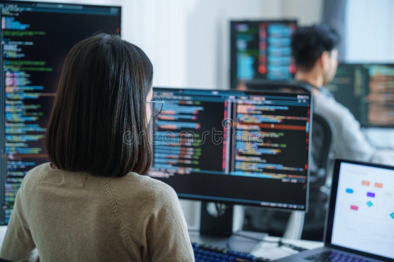 Asian Software Developers Working On Multiple Screens Displaying Code And Application Diagrams