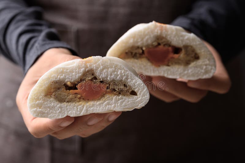 Asian Steamed Bun Stuffed with Pork and Egg Holding by Hand and Eating ...
