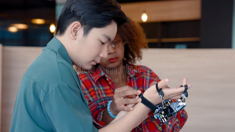 Asian Student Inserts a Finger into a Robotic Hand Controlling a Man ... Asian Student Inserts a Finger into a Robotic Hand Controlling a Man ...