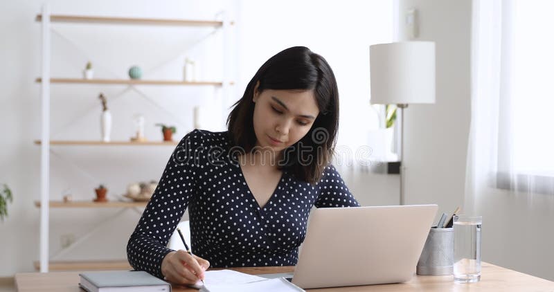 Asian Student Writing in Exercise Book, Prepare Essay Using Laptop ...