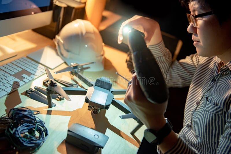 Asian Technical Engineer Using Electric Screwdriver for Repairing Drone ...
