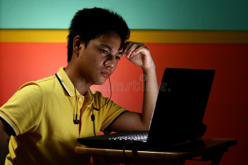 Asian Teen, Intensely Playing or Working on a Laptop Computer Stock ...