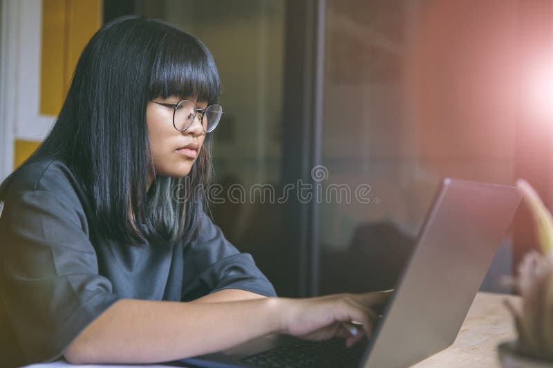 Asian Teenager Sitting in Working Room and Reading Message on Computer ...