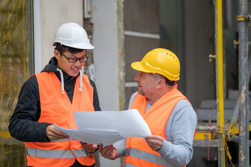 Asian Trainee Engineer at Work on Construction Site with the Senior ...
