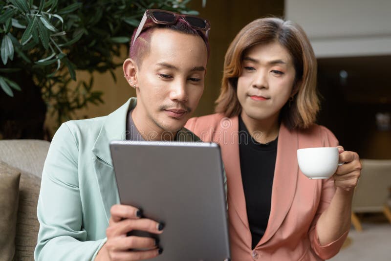Transgender and Non-binary Coworkers Working Remotely in Cafe Stock ...