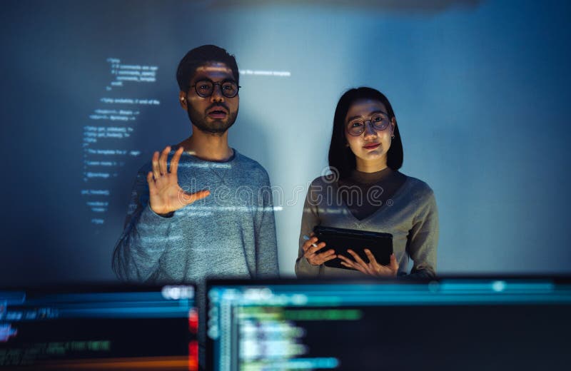 Asian Two Software Developers Engaged in Collaborative Coding Session, with Code Projected Onto ...