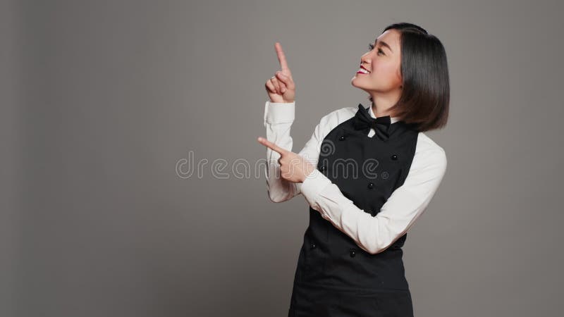 Asian Waitress Pointing Up for an Advertisement in Studio Stock Video ...