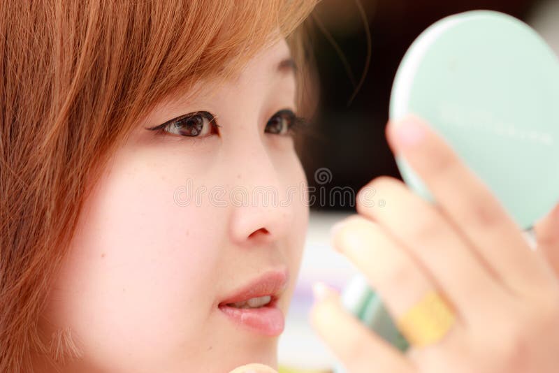 Asian waman making up her face. - Stock Image - Everypixel
