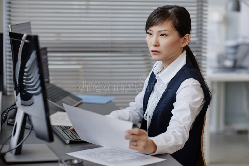 Asian Woman As Female Engineer Using Computer and Blueprints in Office ...