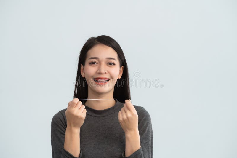 Asian Woman Braces Using Dental Floss Teeth Braces On The White Teeth