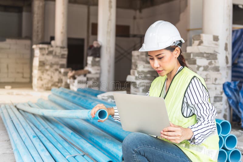 Asian Woman Construction Engineer Using Notebook Computer for Checking ...