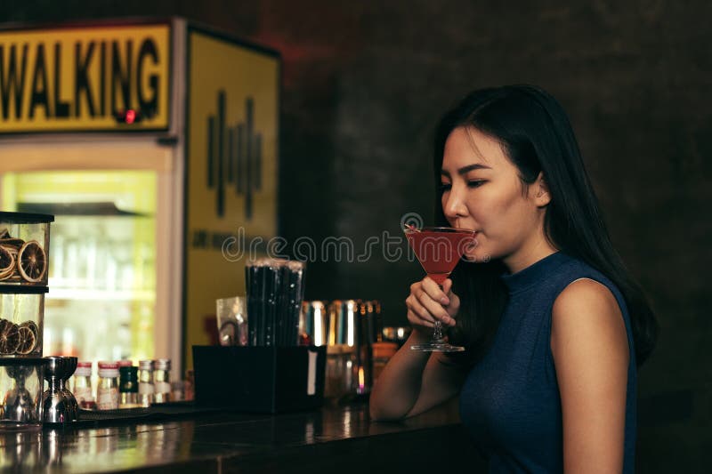 Asian Woman Drinking a Cocktail at a Bar at Night Stock Image - Image ...