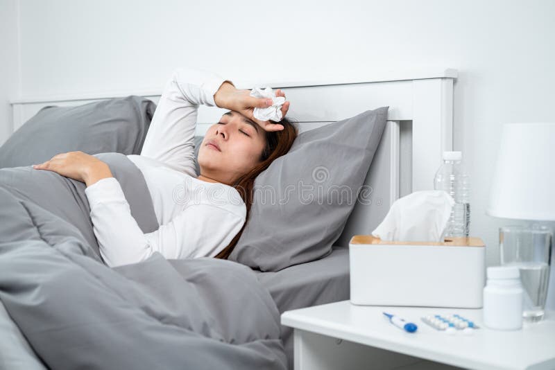 Asian Woman Feeling Sick and Sleeping in Blanket on the Bed while ...