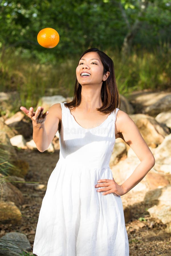 Asian Woman Having Fun Throwing an Orange in the Air Stock Image ...
