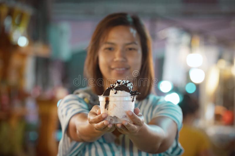 Asian Woman Holding Delicious Ice Cream Dessert In A Cup In Night