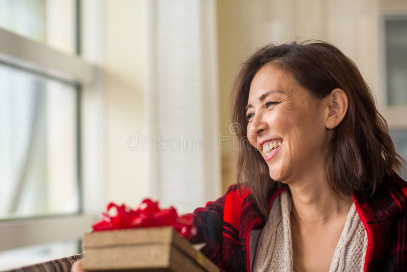 Asian Woman Holding a Gift Sitting on the Sofa. Stock Image - Image of ...
