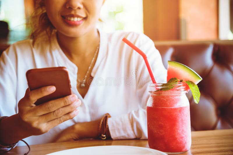 Asian Woman Sit Back and Relax Drink Fruit. and the Phone is Holding ...