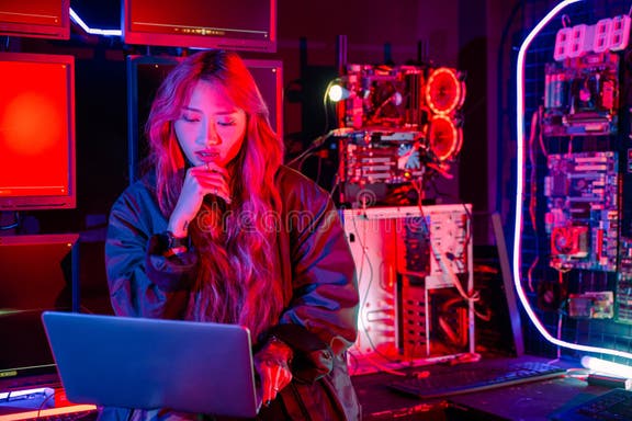 Asian Woman is Sitting at a Desk with a Laptop Service in Server Room ...