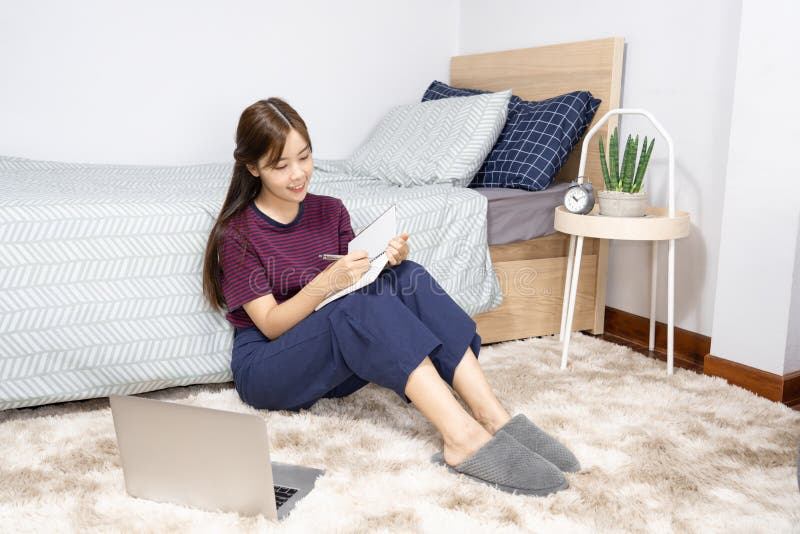 Asian Woman Using Laptop Computer on the Bed and Enjoy Working at Home ...
