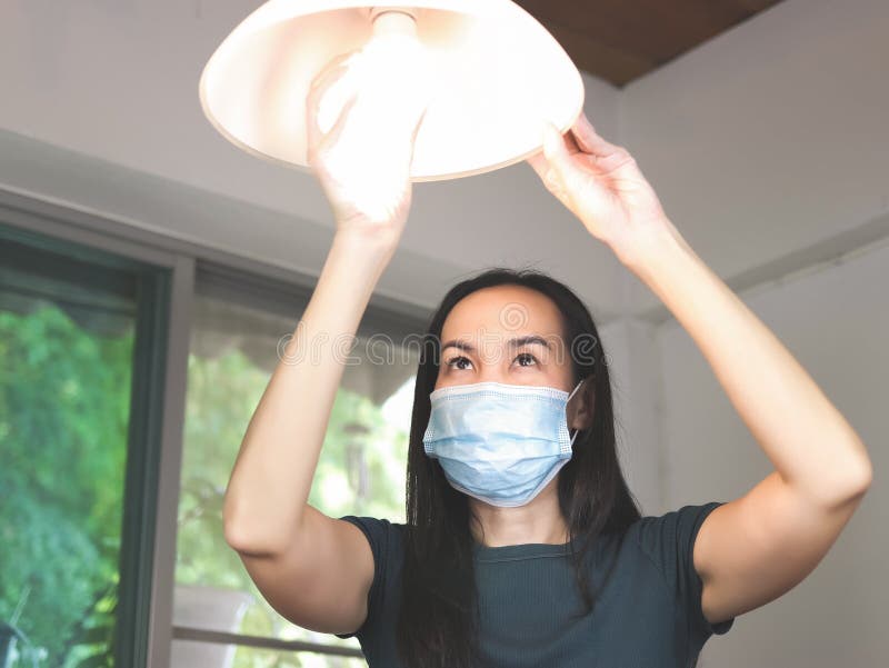 Woman Wearing Protective Face Mask, Changing Light Bulb Stock Image ...