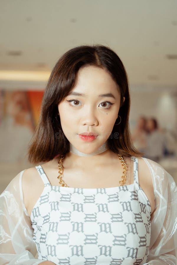 Asian Woman Wearing A White Motif Tank Top In Make Up And Black Hair